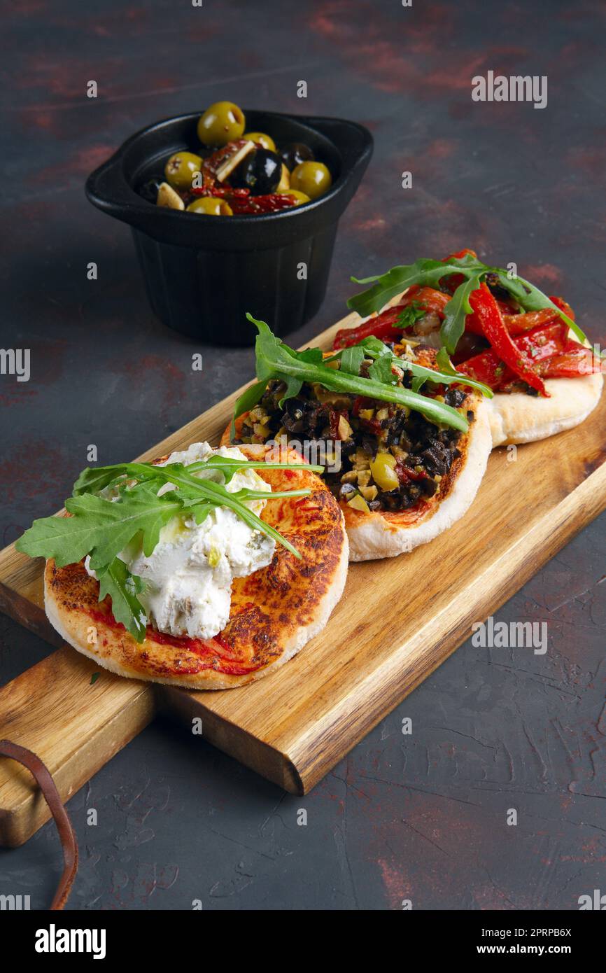 Delicious tapas set. Small sandwiches with goat cheese, chopped olives ...