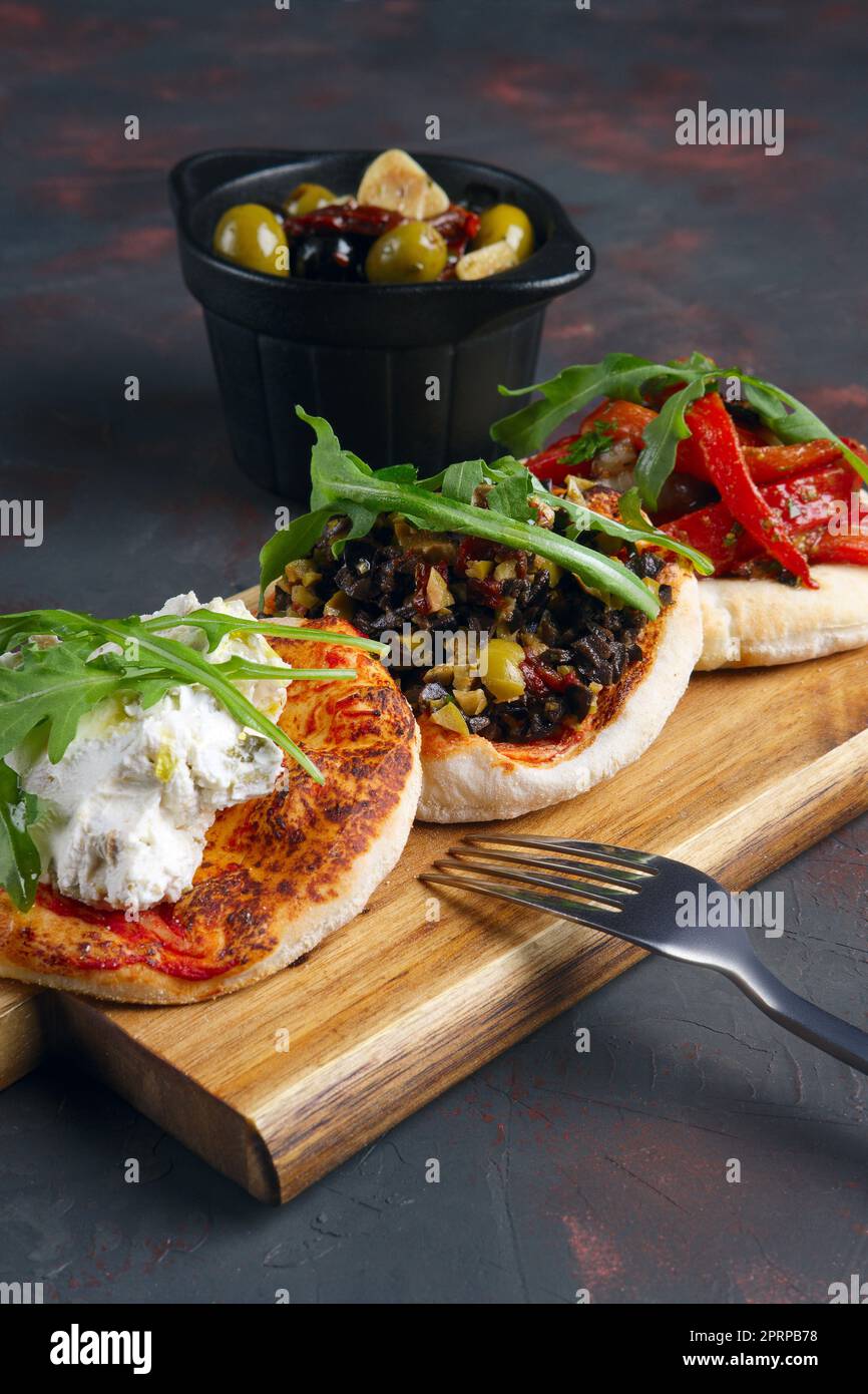 Delicious tapas set. Small sandwiches with goat cheese, chopped olives ...
