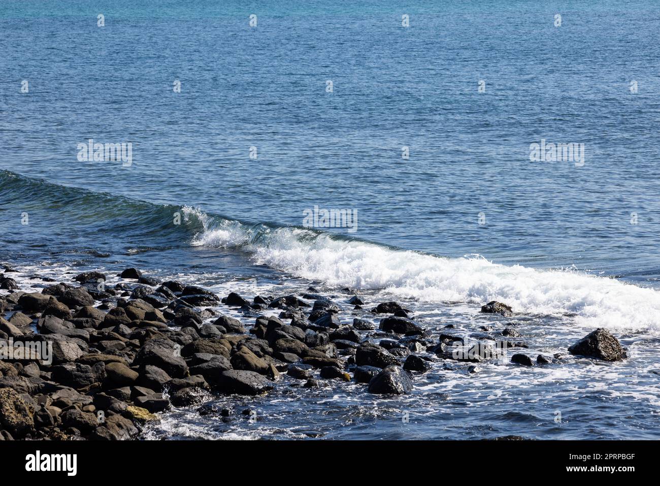 Sea wave splash over the stone beach Stock Photo - Alamy