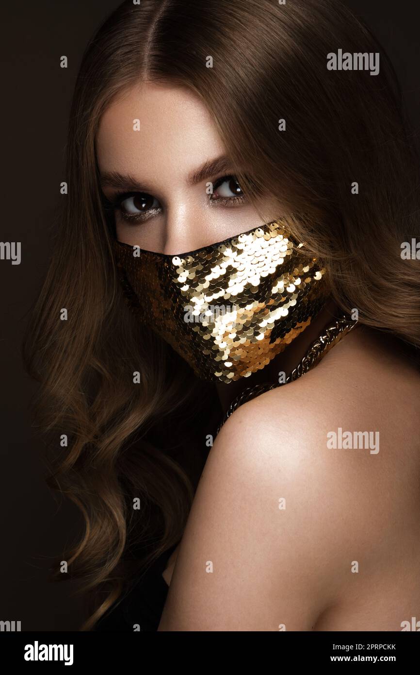 Portrait of a beautiful woman in a gold mask with sequins and classic ...