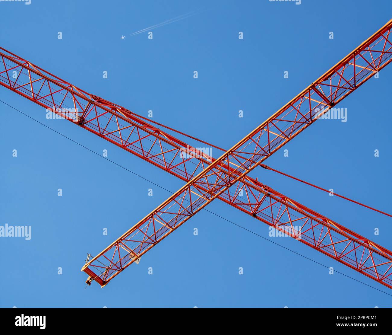 a perspective view of two orange crane booms crossing each other in ...