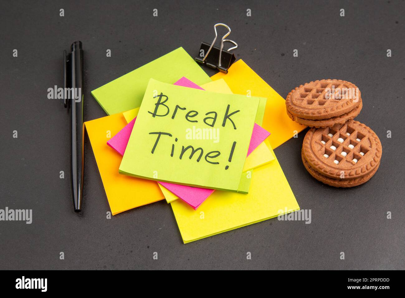 bottom view break time written on sticky note binder clip pen biscuits ...