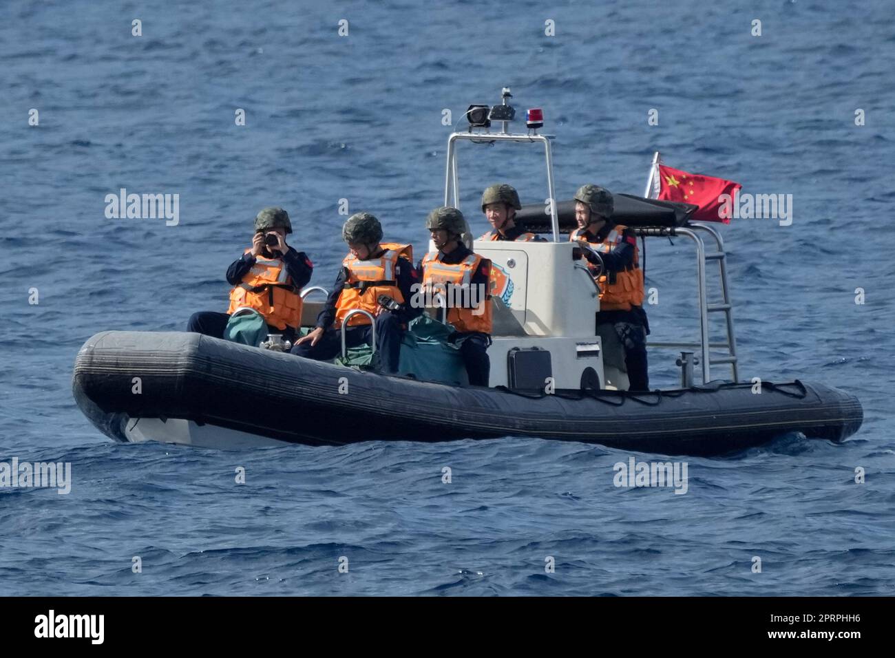 The crew of a Chinese Coast Guard ship takes pictures as they monitor activities of Philippine ...