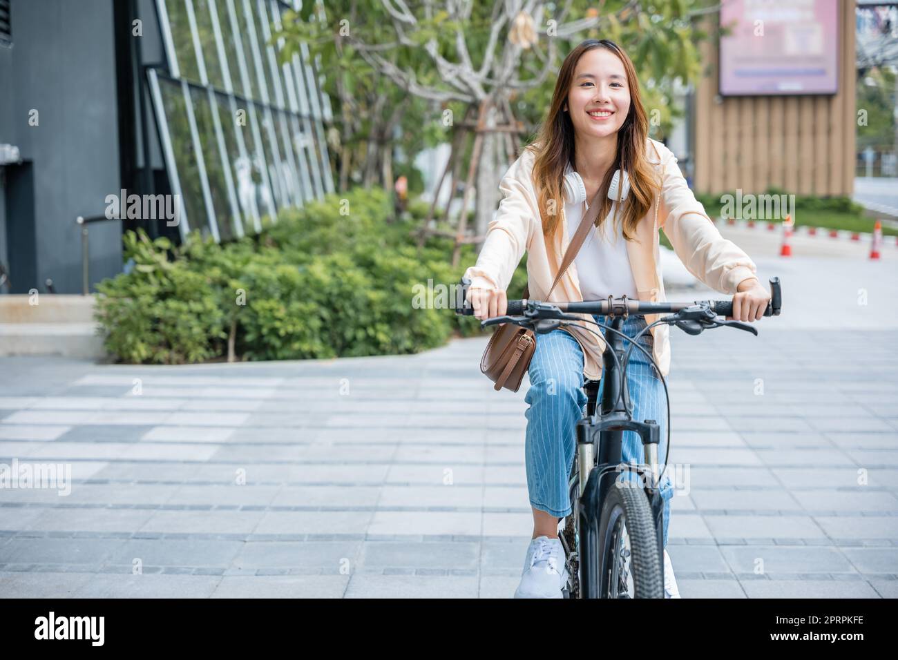 Happy Asian beautiful young woman riding bicycle on street outdoor near ...
