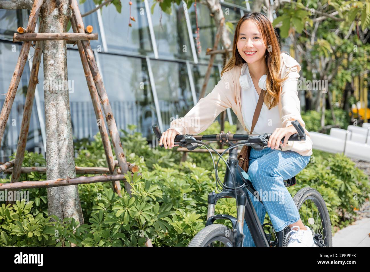 Happy Asian beautiful young woman riding bicycle on street outdoor near ...