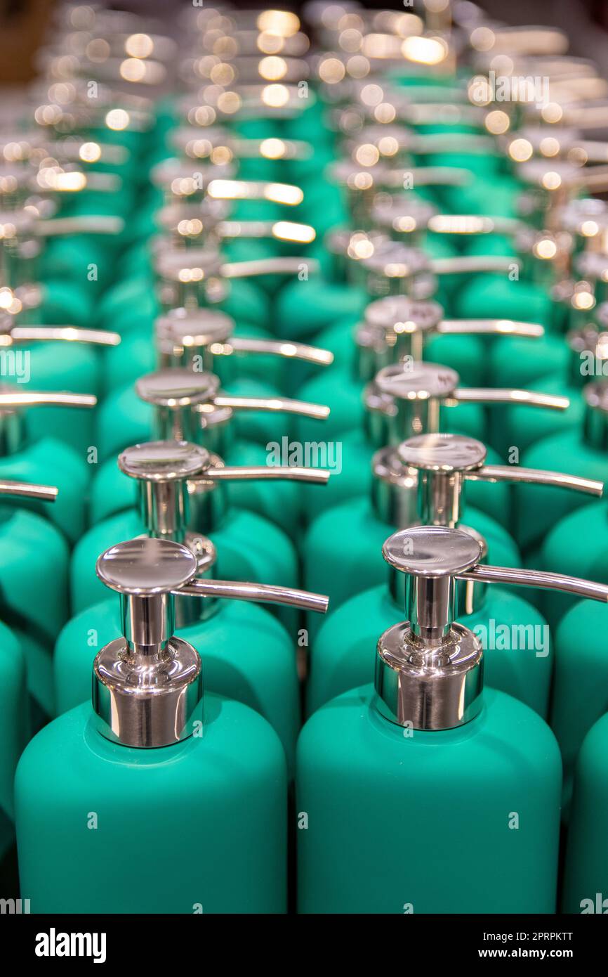 Selective focus on the front part of a group of green spray bottles in ...