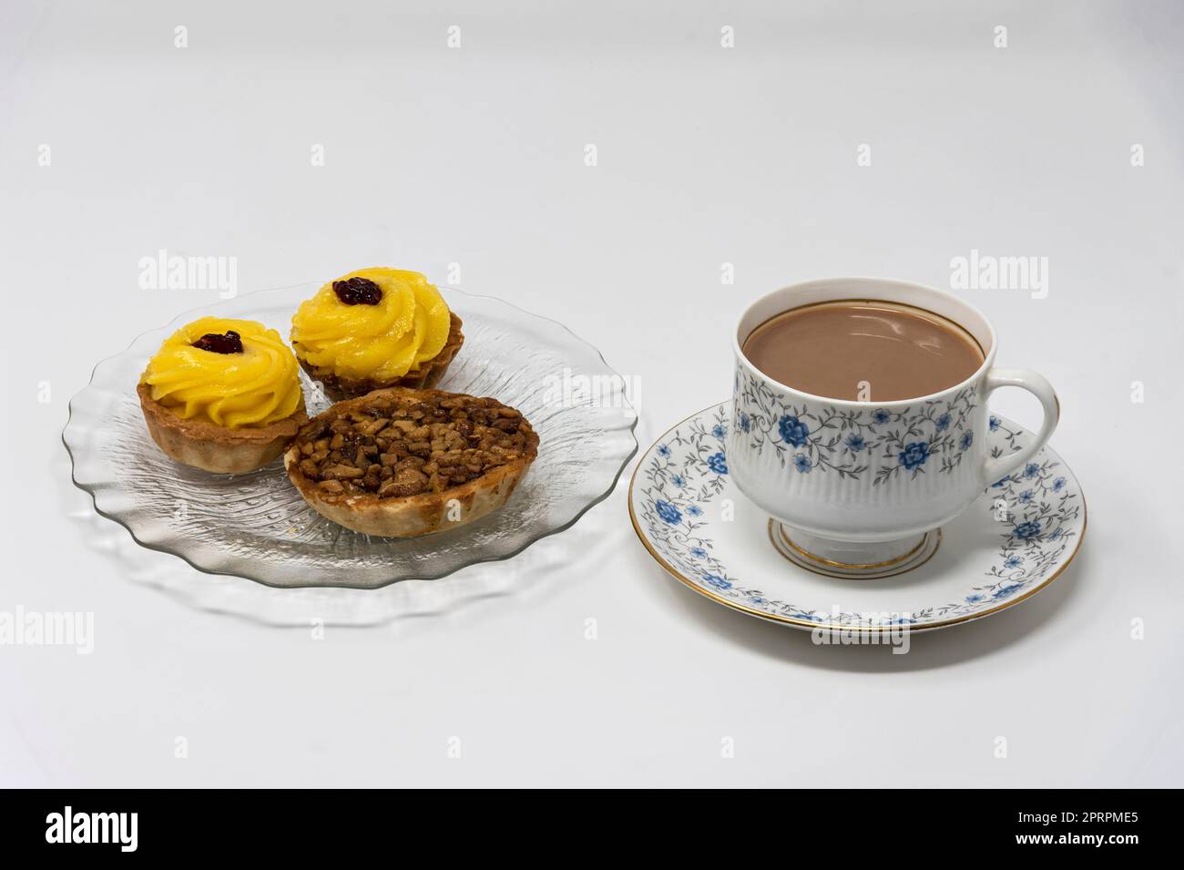 Walnut pie, lemon tart, hot tea with milk Stock Photo - Alamy