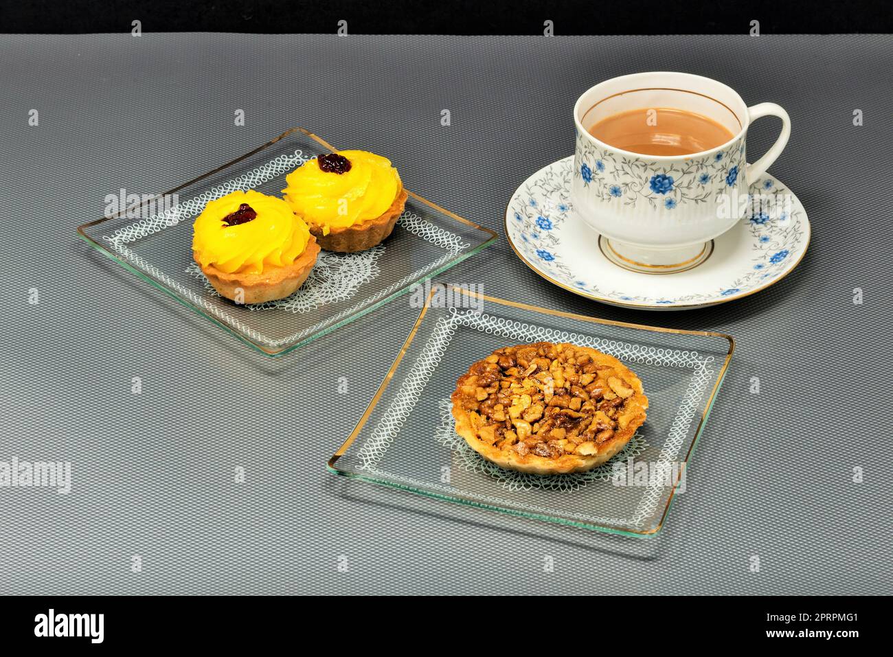 Walnut pie, lemon tart, hot tea with milk Stock Photo - Alamy