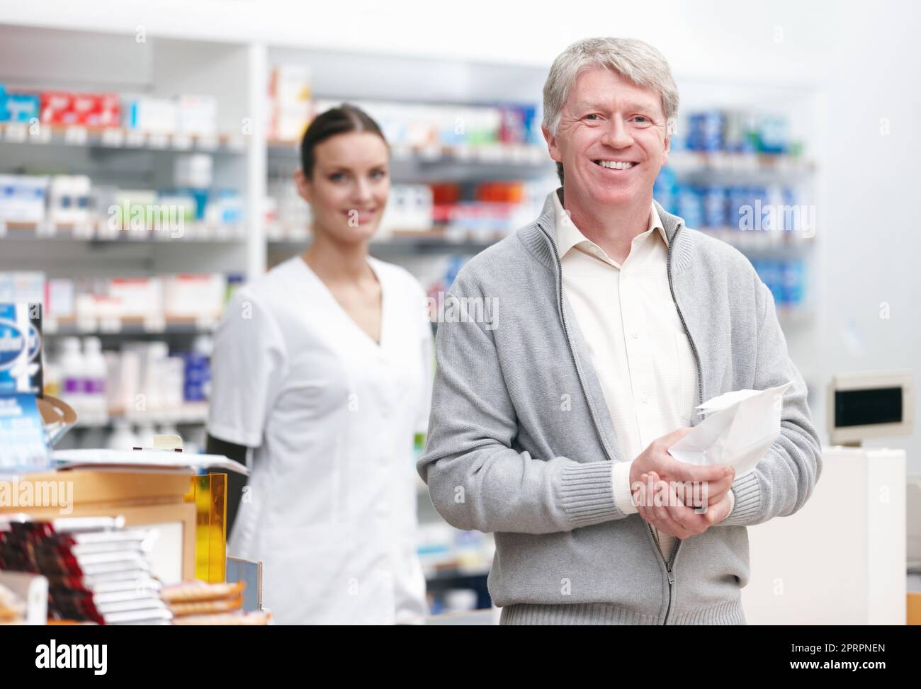 Customer holding package with pharmacist. Portrait of mature customer ...
