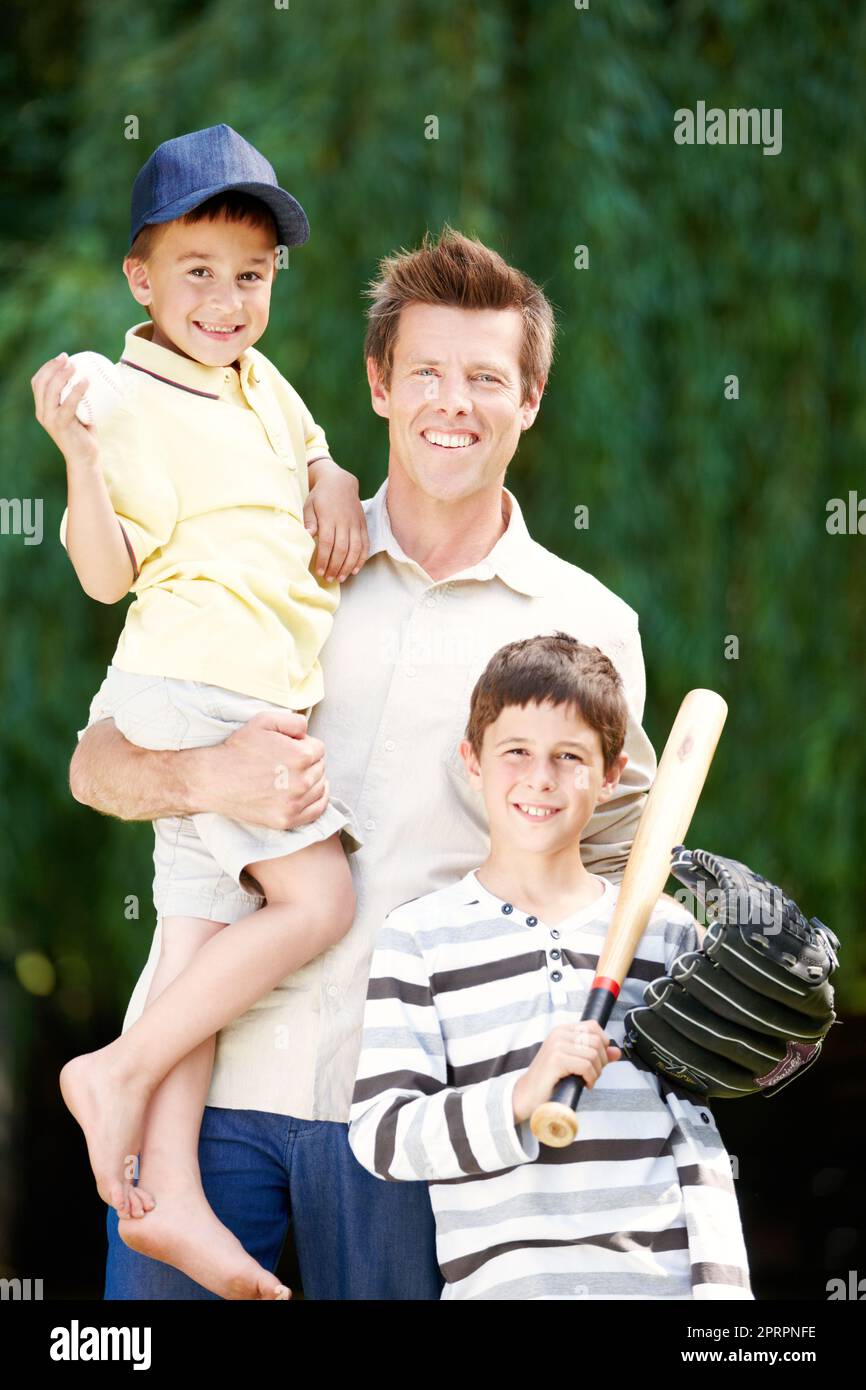 A home run of a portrait. Portrait of a proud father embracing his two ...