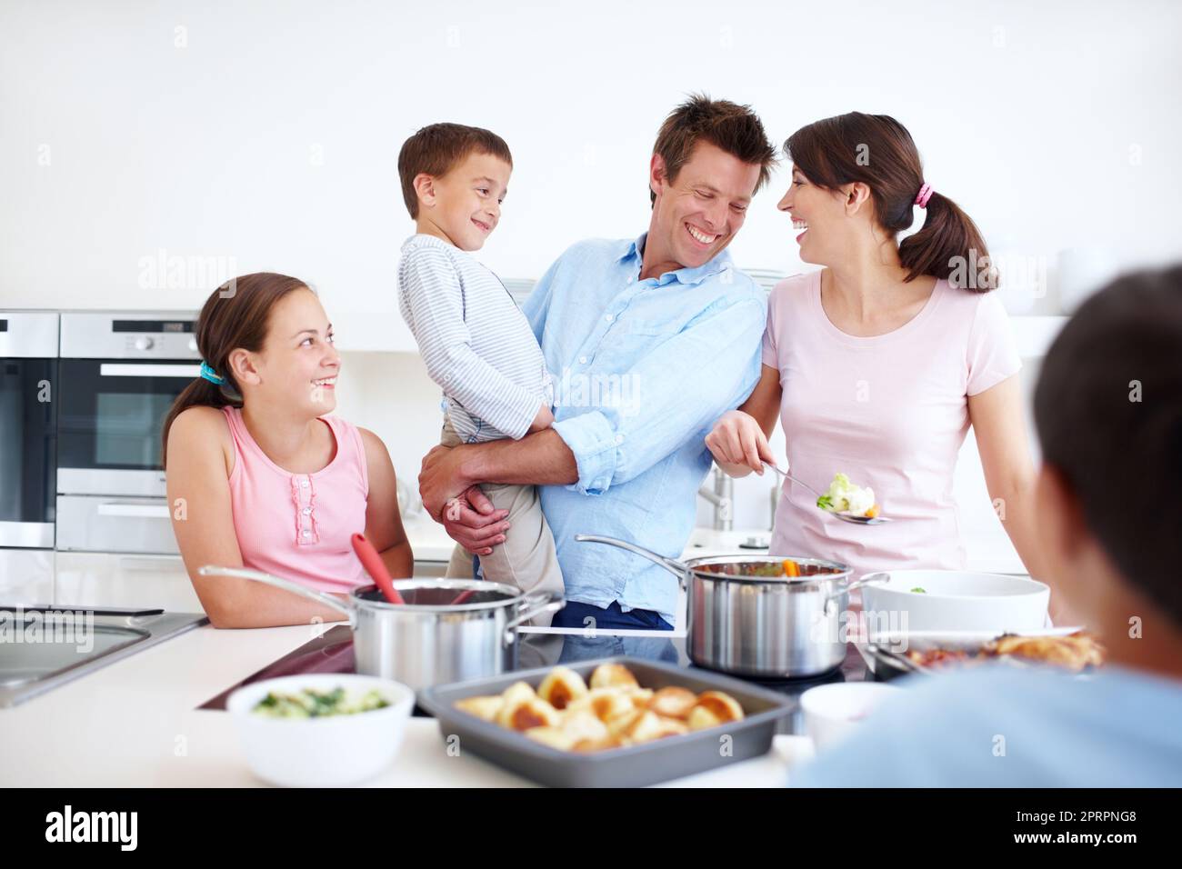 Bonding together in the kitchen. A happy family cooking a large ...
