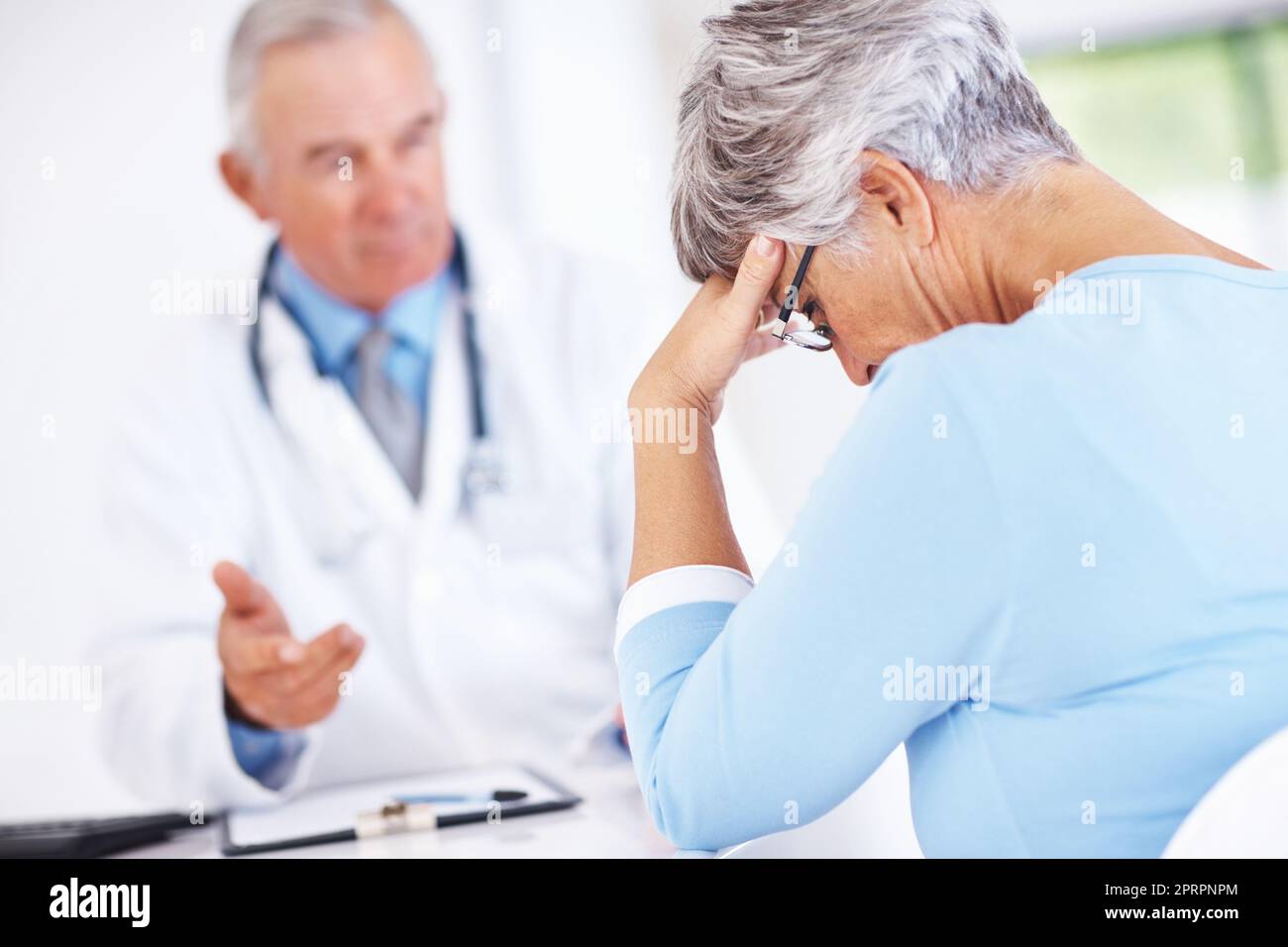 Mature doctor with unhappy patient. Mature doctor discussing medical ...