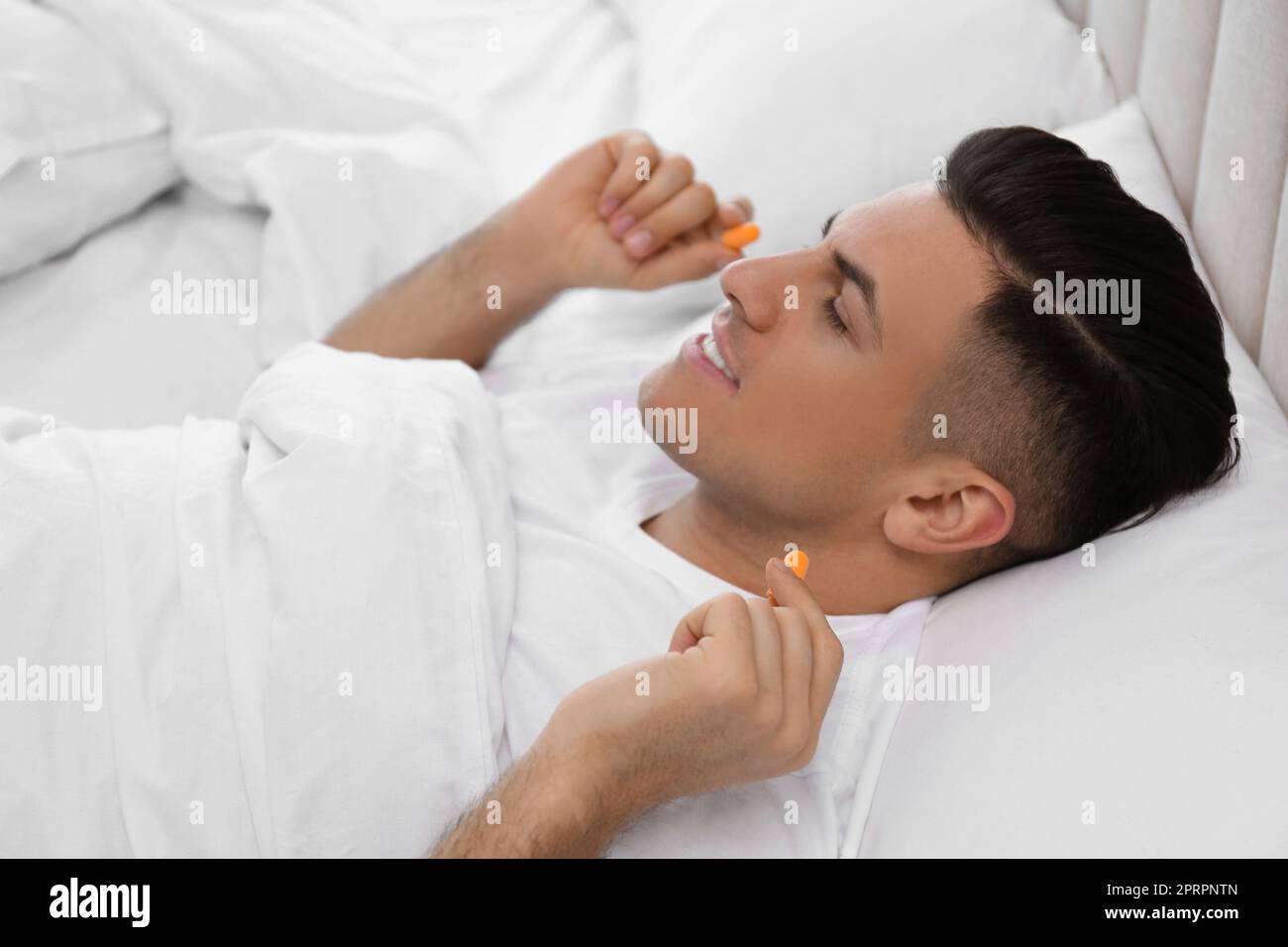 Man inserting foam ear plugs in bed Stock Photo - Alamy Man inserting foam ear plugs in bed Stock Photo - Alamy