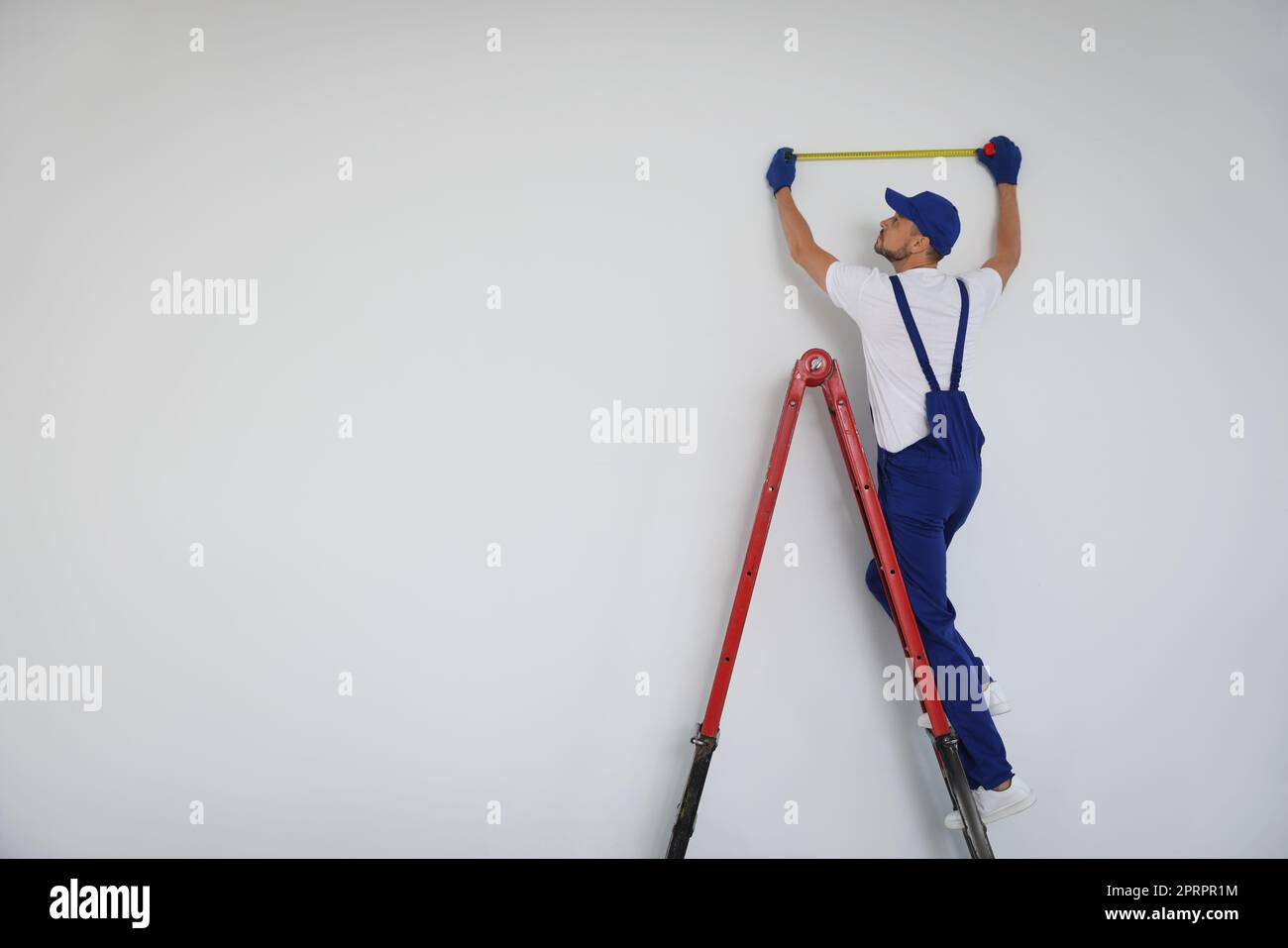 Construction worker using measuring tape indoors. Room renovation Stock ...