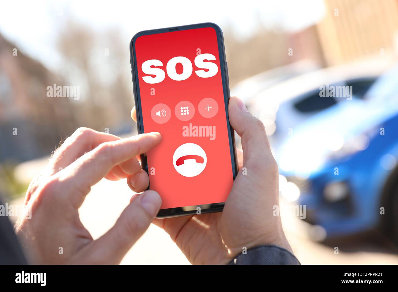 Man holding smartphone with emergency call SOS on screen outdoors ...