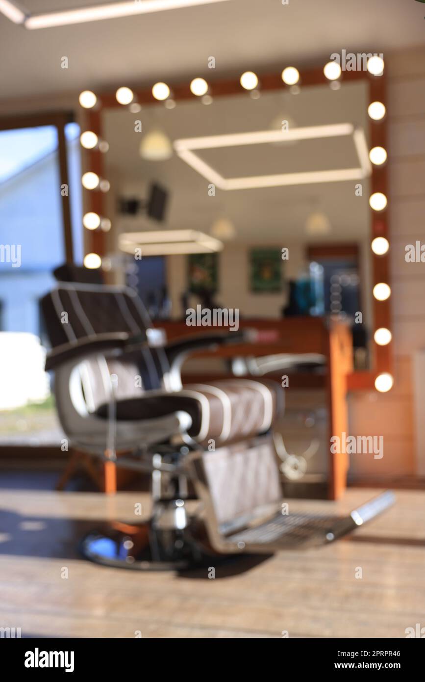 Blurred view of stylish barbershop interior with hairdresser workplace ...