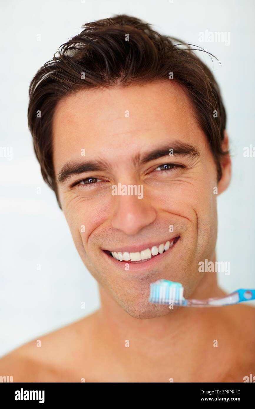 Closeup of a happy young man about to brush his teeth. Personal Hygiene ...