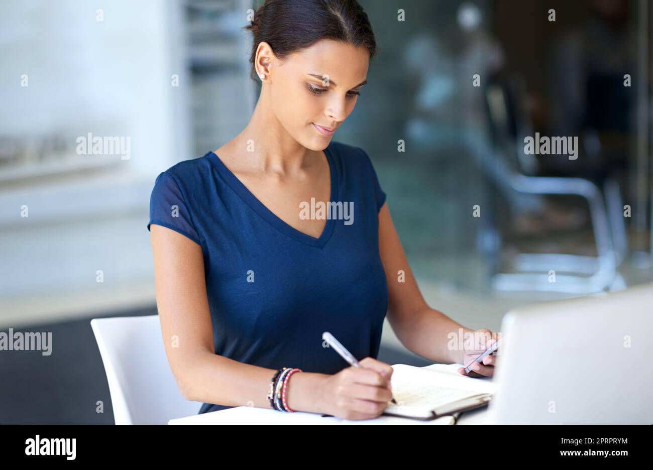 Scheduling an appointment. an attractive businesswoman at work in an ...