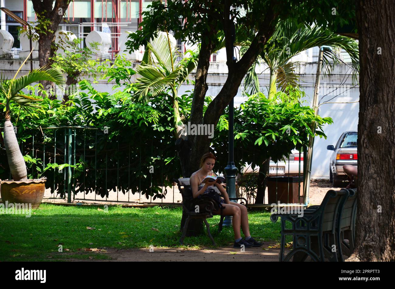 Foreign women travelers sitting rest relax reading book on bench in ...
