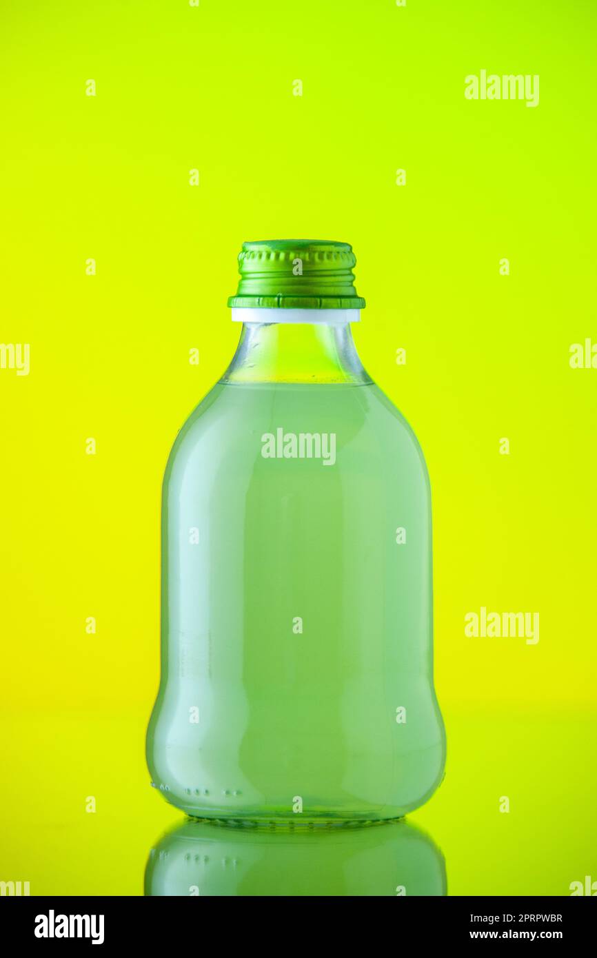 front view glass bottle with green juice on yellow background Stock ...