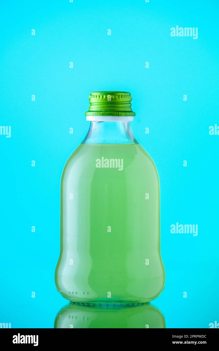 front view glass bottle with green juice on light blue background Stock ...