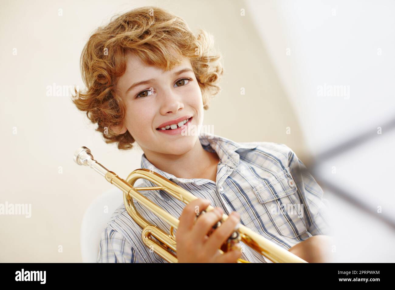 Music makes me happy. a cute little boy playing the trumpet Stock Photo ...