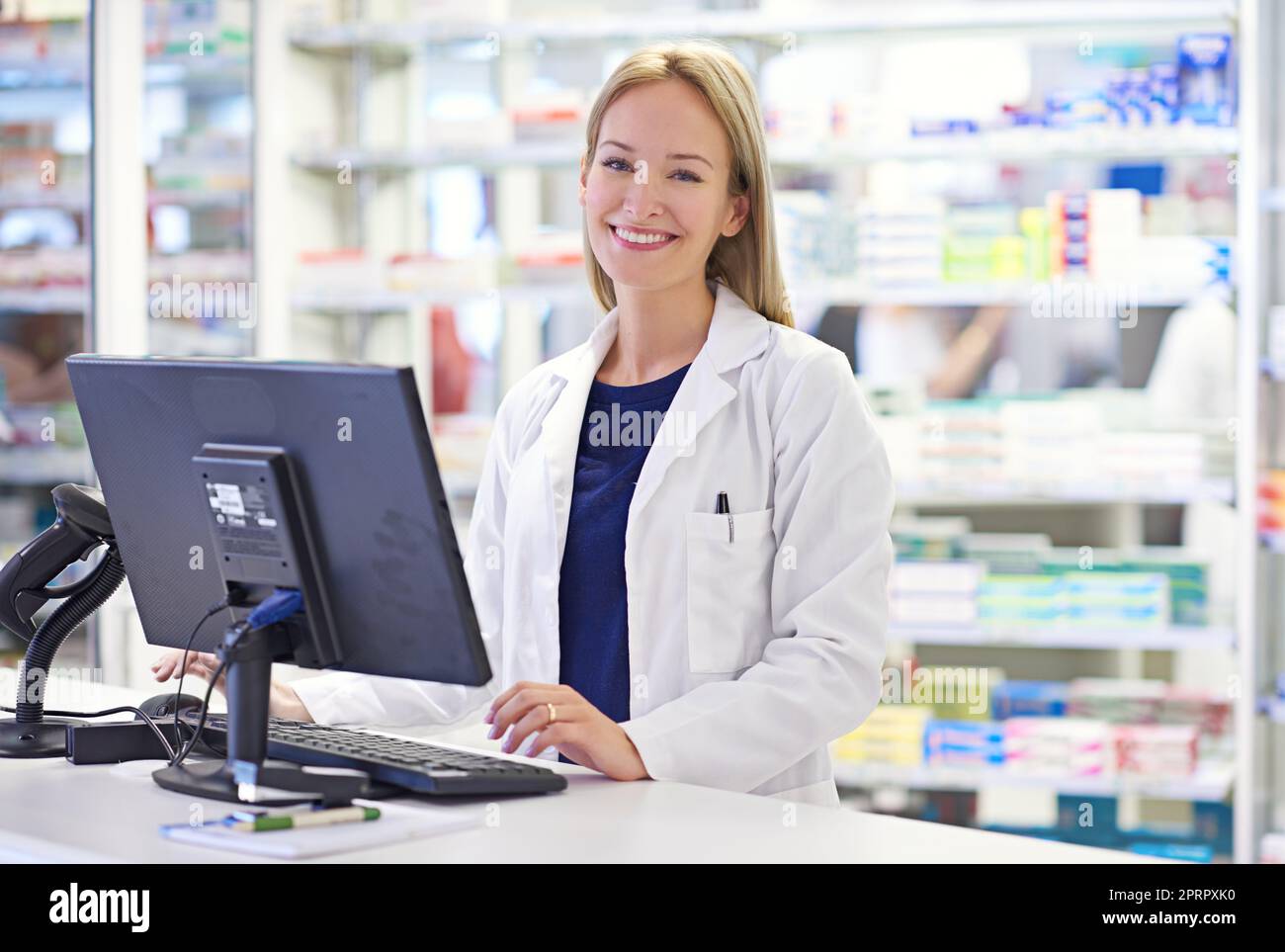 How may I help today. Portrait of an attractive pharmacist using a ...