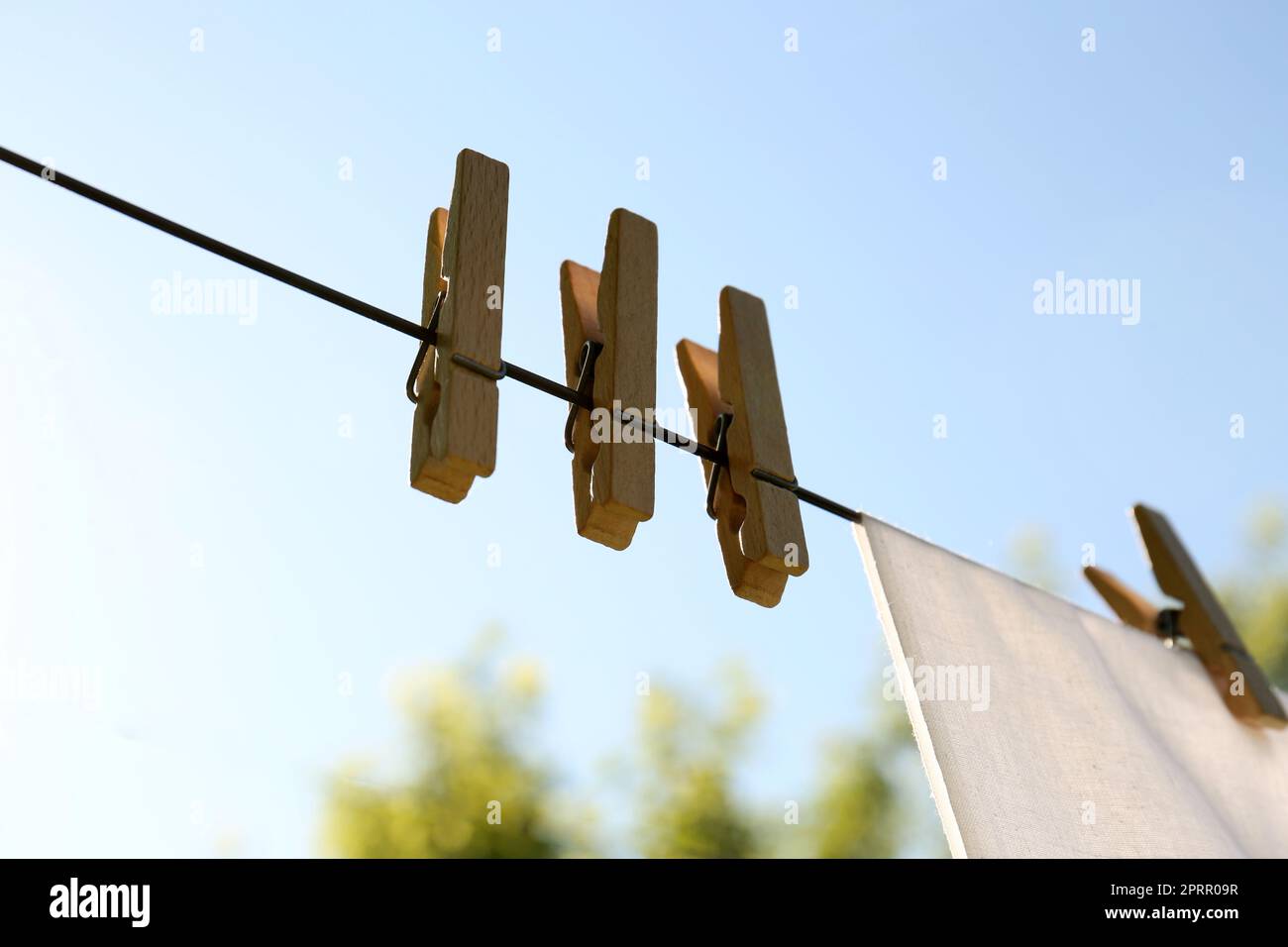 Wooden clothespins hanging on washing line outdoors Stock Photo - Alamy