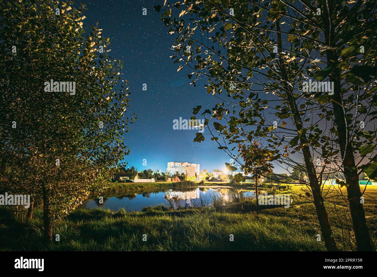 Night Sky Over River Lake Near Residential Houses. Night Starry Sky ...
