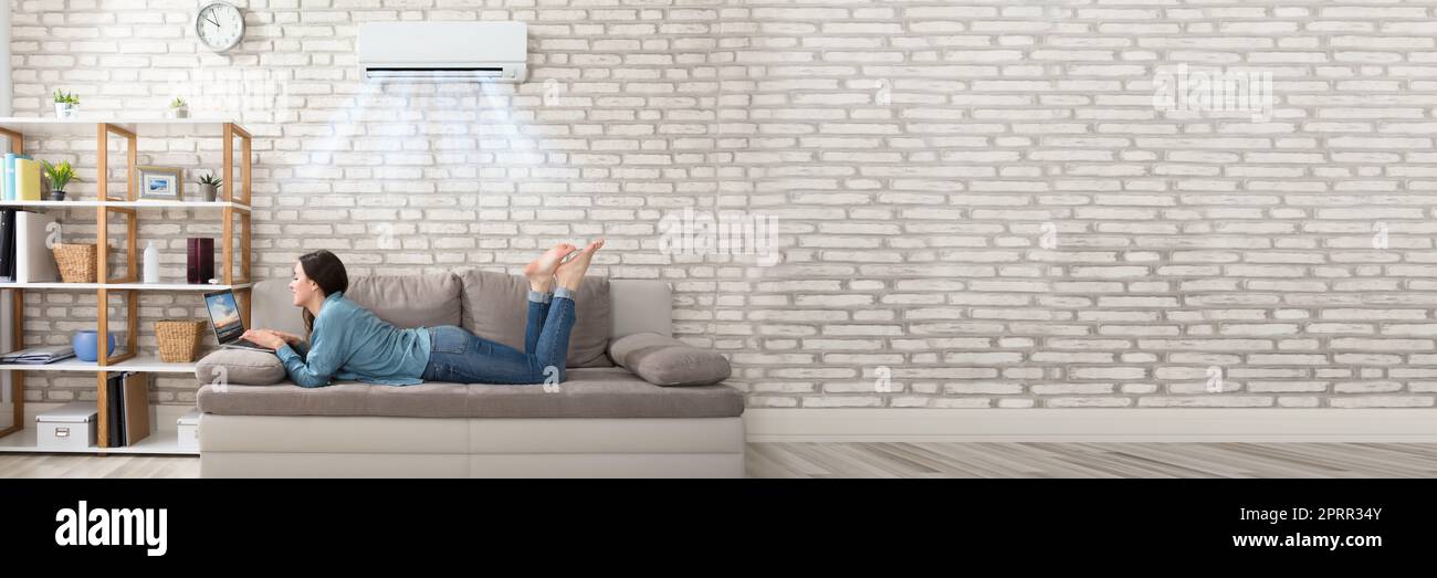 Air Conditioner In House. Woman Relaxing Under Conditioning System ...