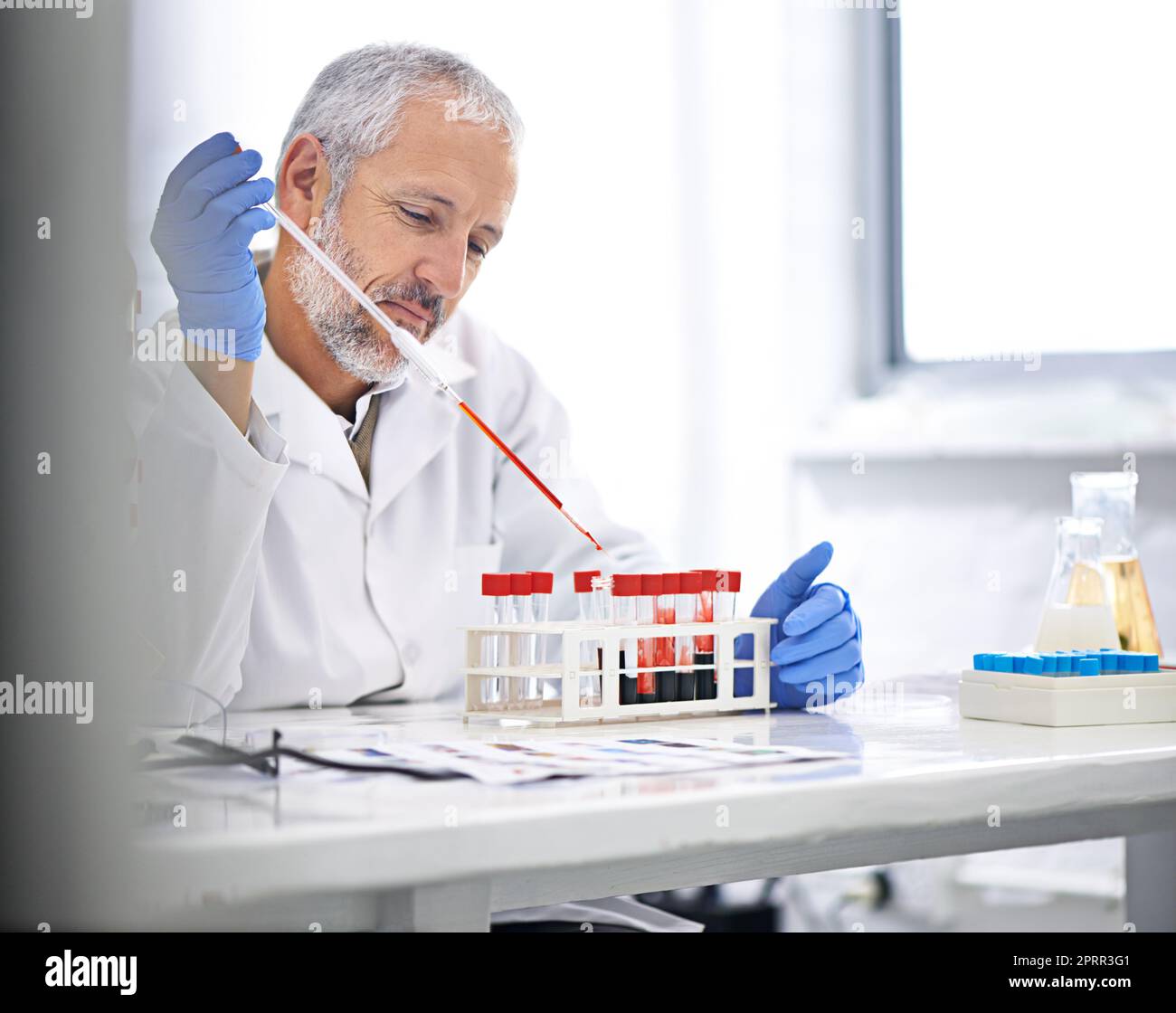 Just another day ion the lab. a mature male scientist conducting blood ...