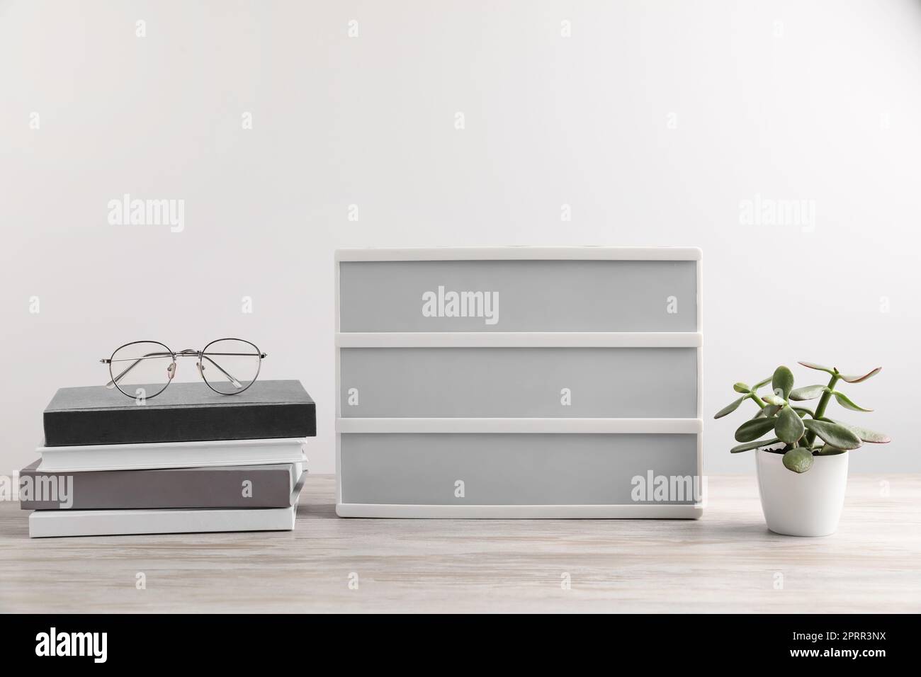 Blank letter board, books, glasses and beautiful houseplant on wooden ...