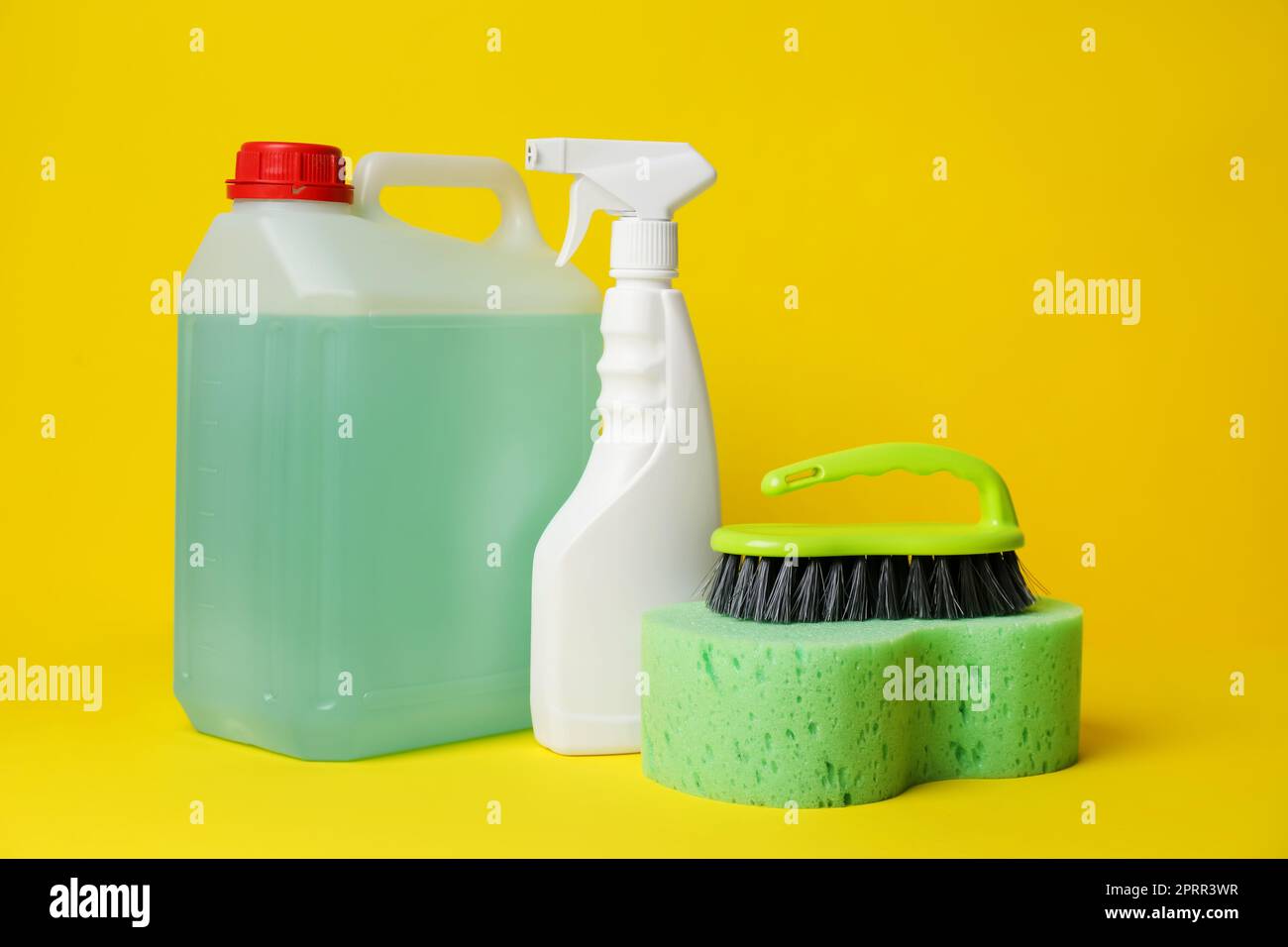 Bottles of detergents and tools on yellow background. Cleaning supplies ...