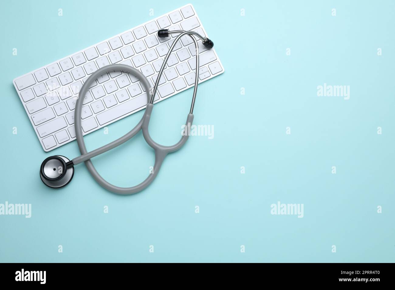 Computer keyboard with stethoscope on turquoise background, top view ...