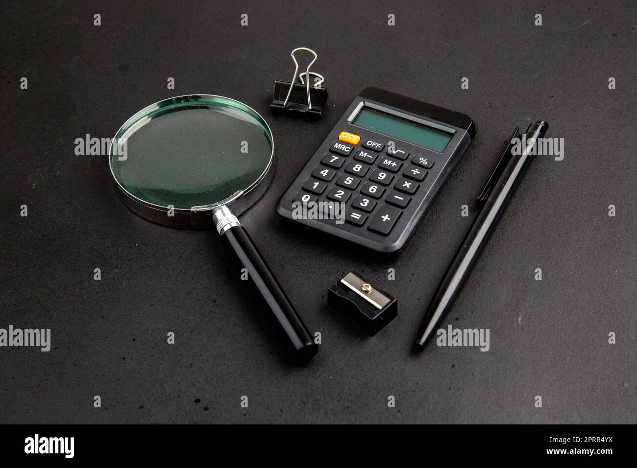 bottom view lupa and calculator binder clip pen pencil sharpener on ...