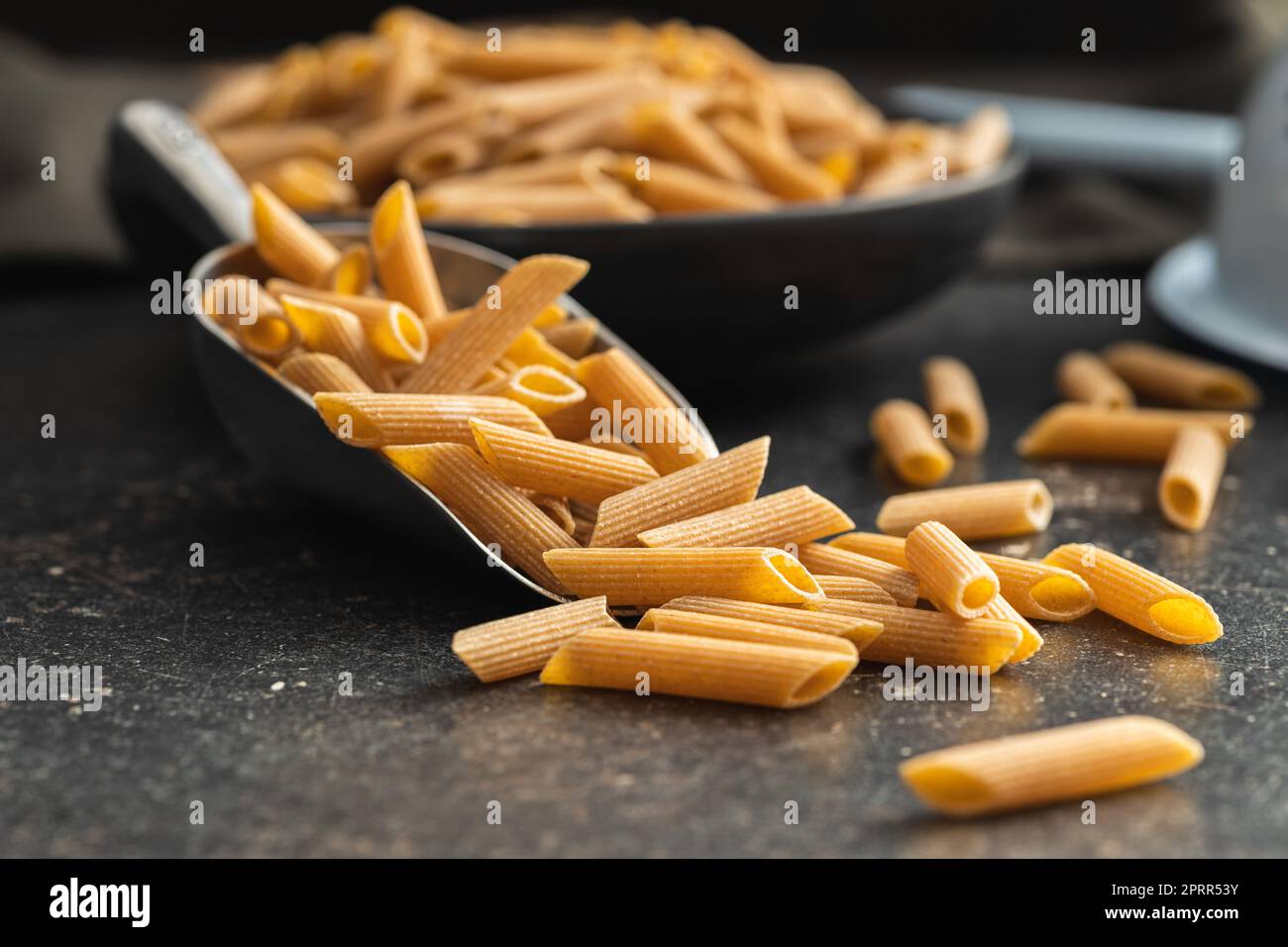 Uncooked whole grain pasta. Raw penne pasta in the scoop Stock Photo ...