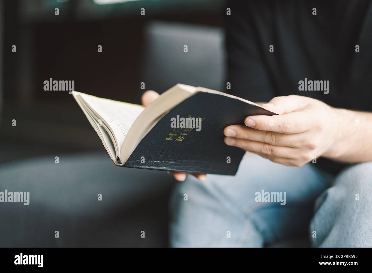 Christian man holds holy bible in hands. Reading the Holy Bible in a ...