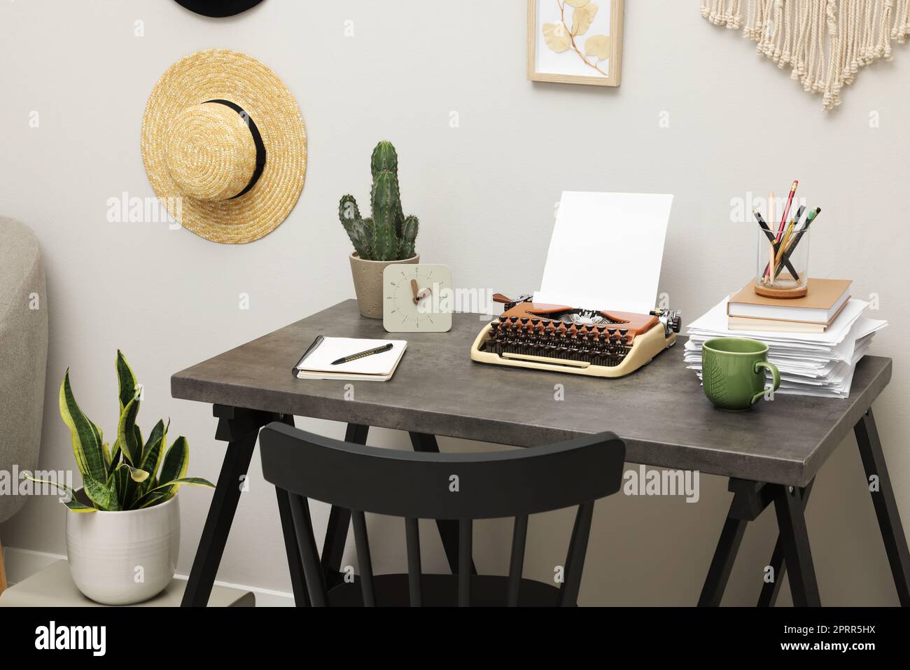 Typewriter and stack of papers on dark table in room. Writer's ...
