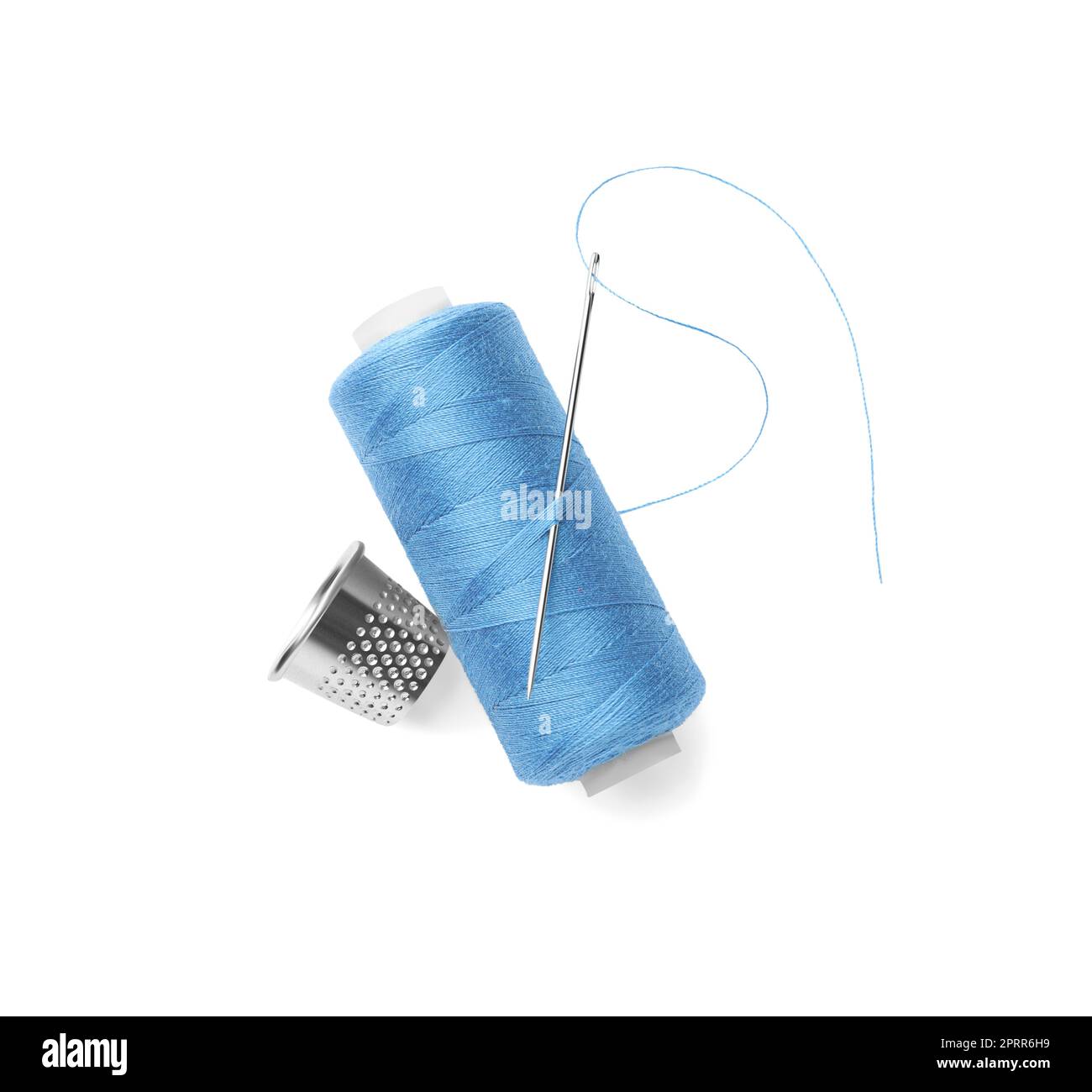 Spool of light blue sewing thread with needle and thimble on white ...