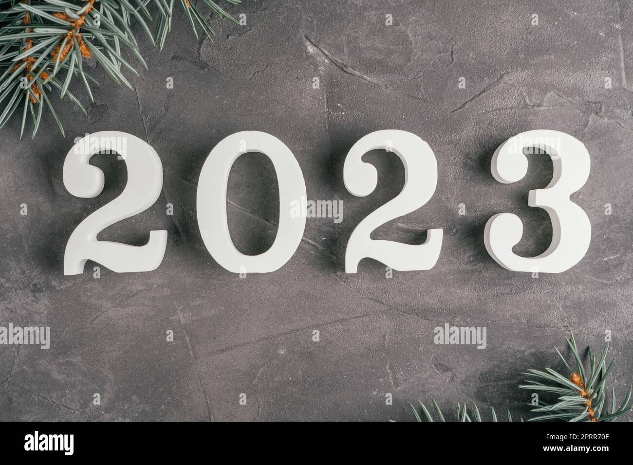 Happy New Year 2023. White wooden numbers 2023 lying on gray uneven ...