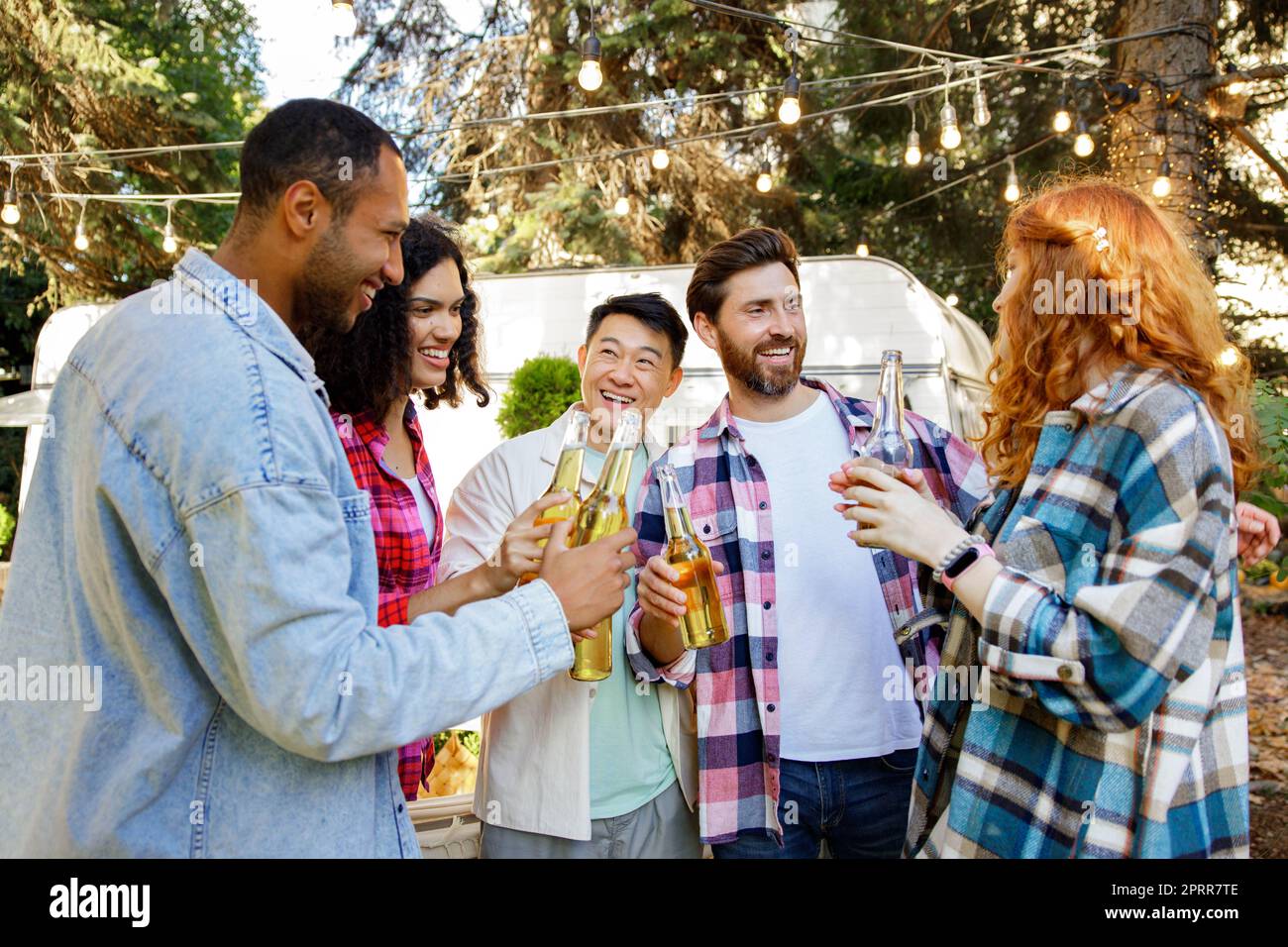 A cheerful multinational company is having fun on a picnic. Multisex ...