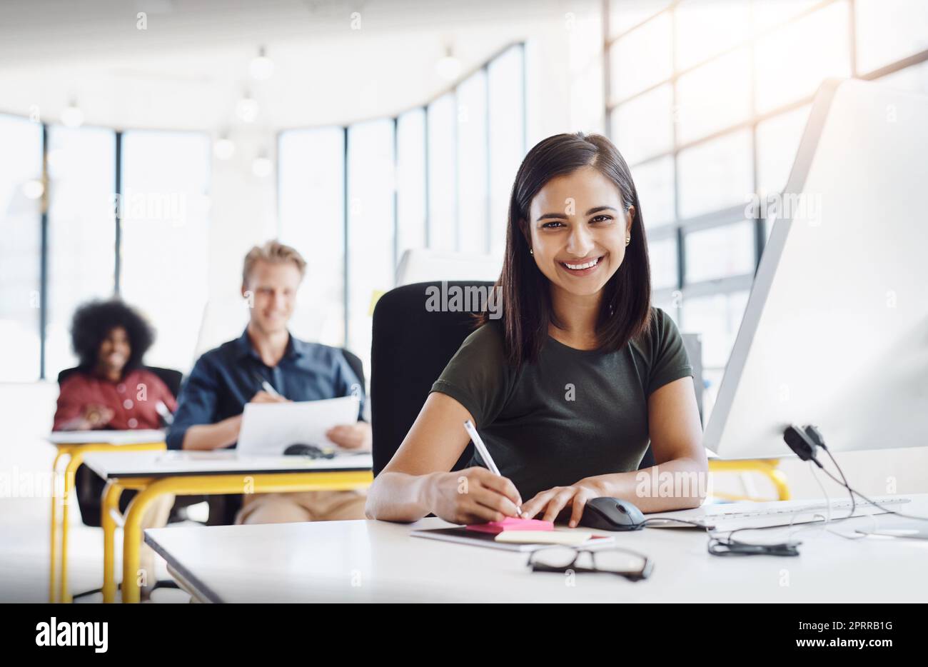 Write your own script to success. Portrait of a happy designer sitting ...