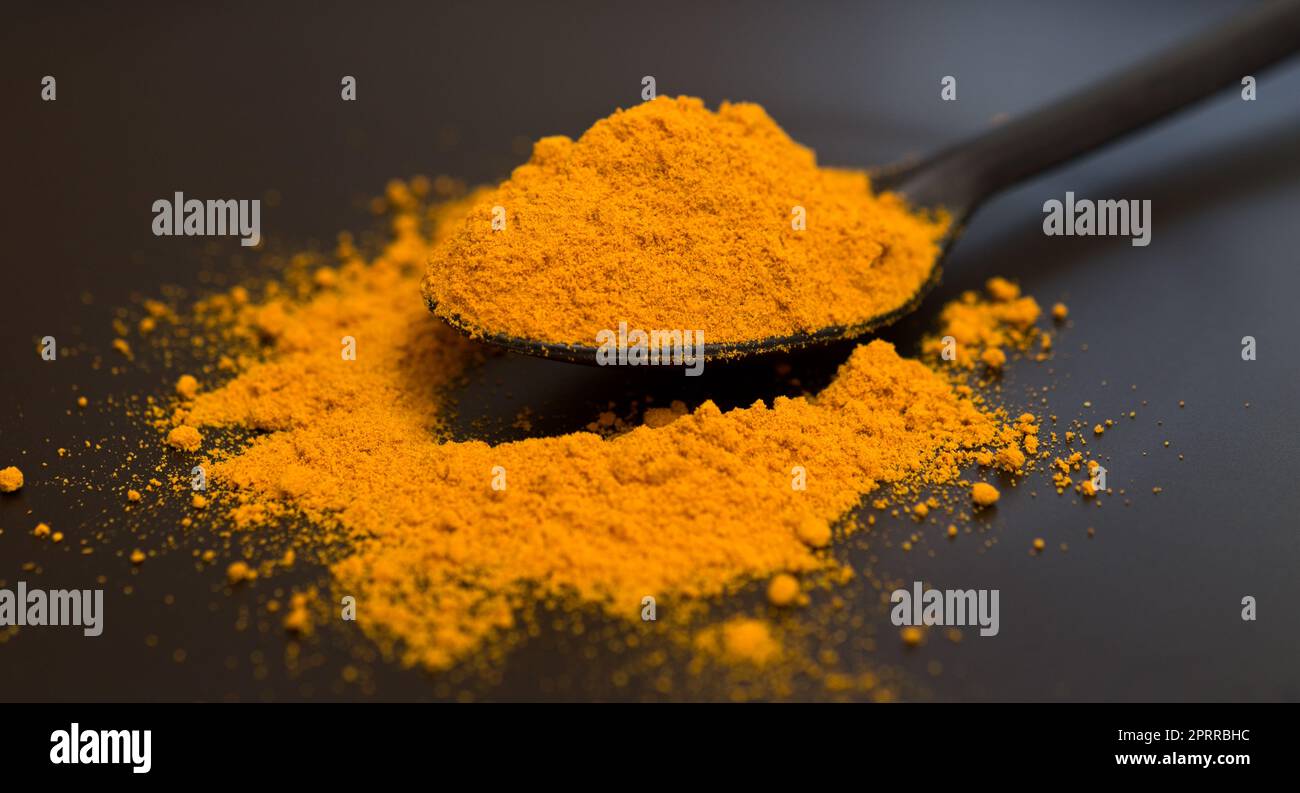 Turmeric on black background, side view Stock Photo - Alamy