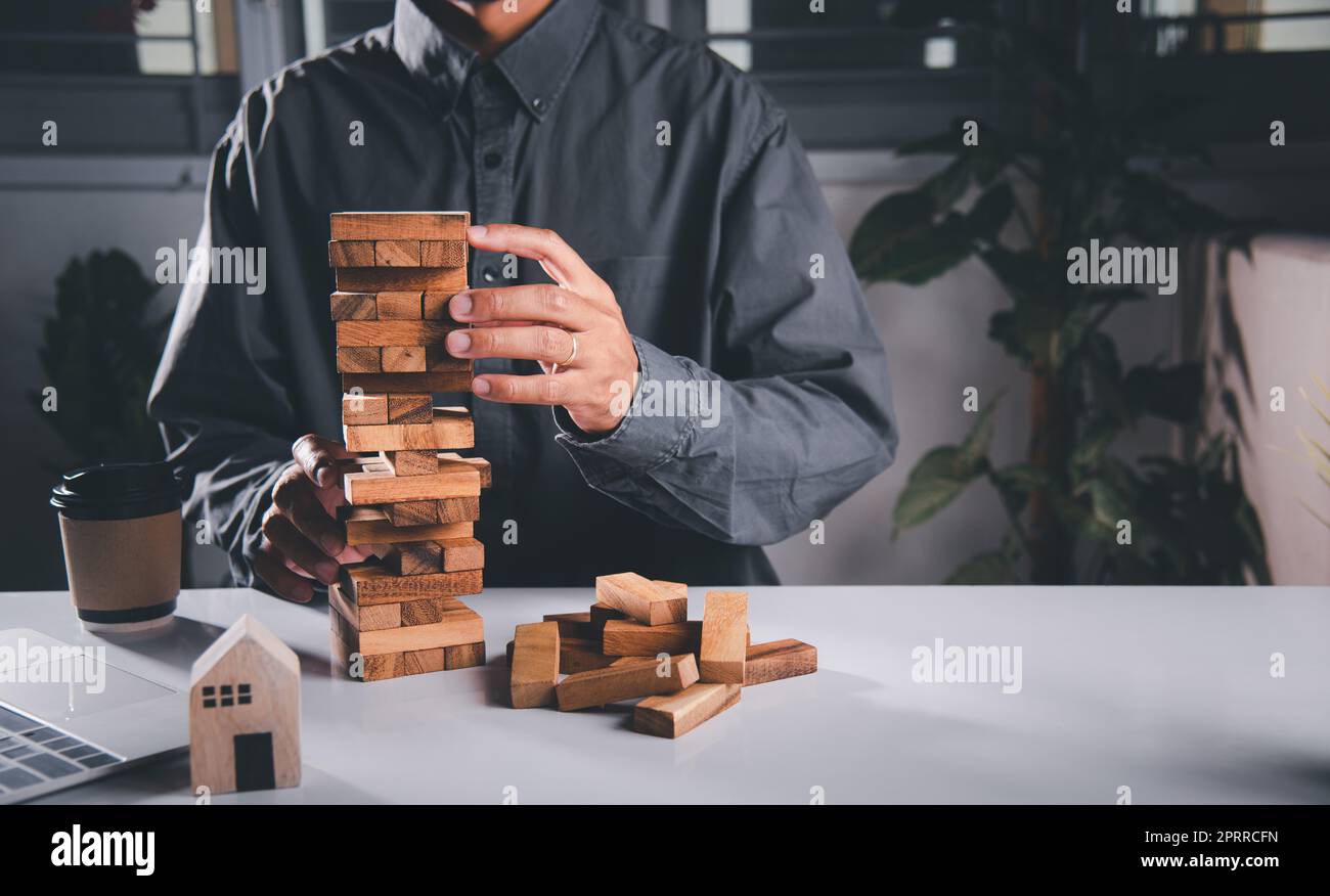 Alternative risk plan. Business hand playing tower wooden blocks game ...