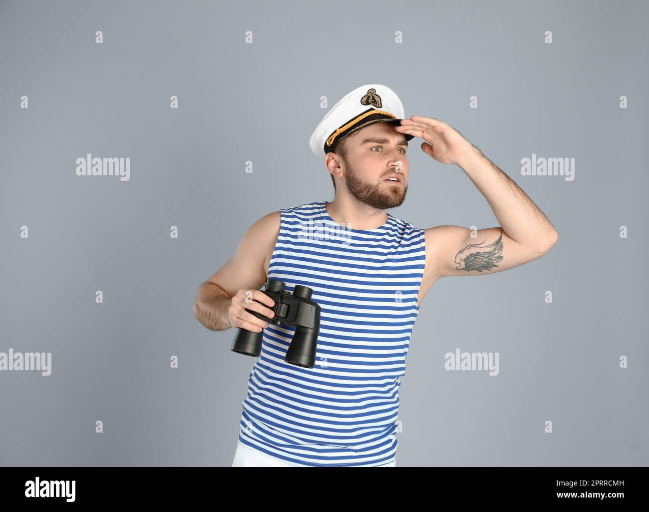Sailor with binoculars on light grey background Stock Photo - Alamy