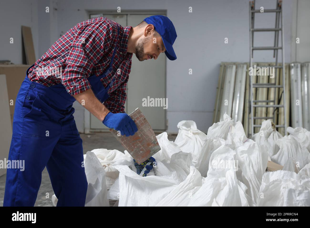 Construction worker with used building materials in room prepared for ...