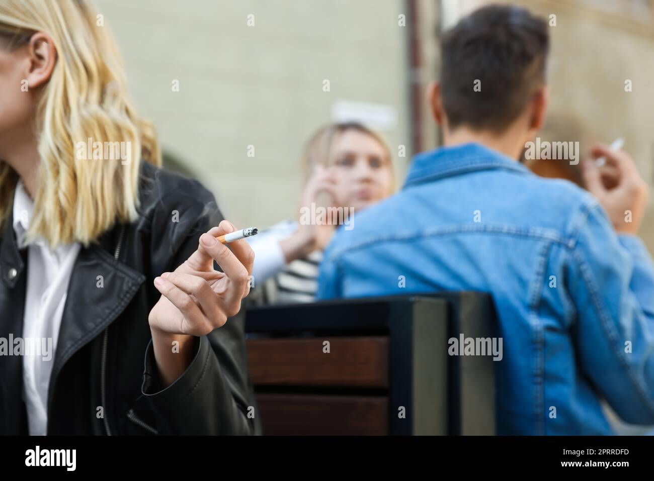 People smoking cigarettes at public place outdoors, closeup. Space for ...
