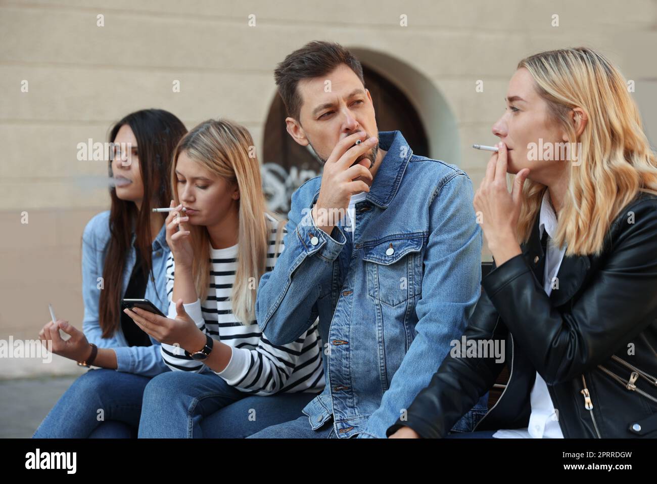 People smoking cigarettes at public place outdoors Stock Photo - Alamy