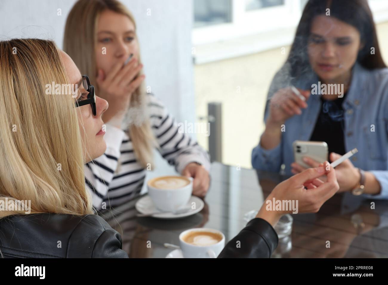Women smoking cigarette at table in outdoor cafe Stock Photo - Alamy