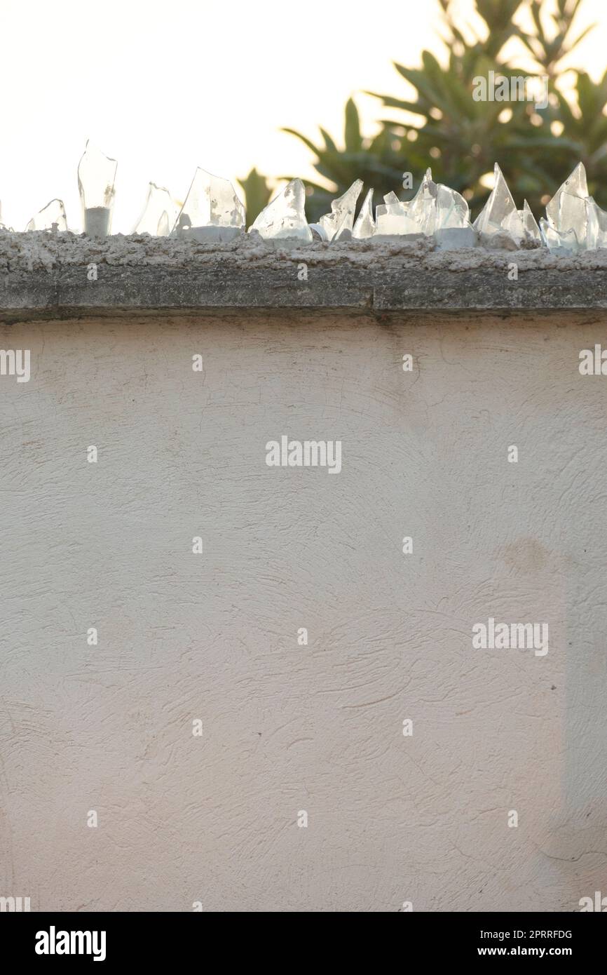 Broken glass used for house protection from thiefs Stock Photo - Alamy